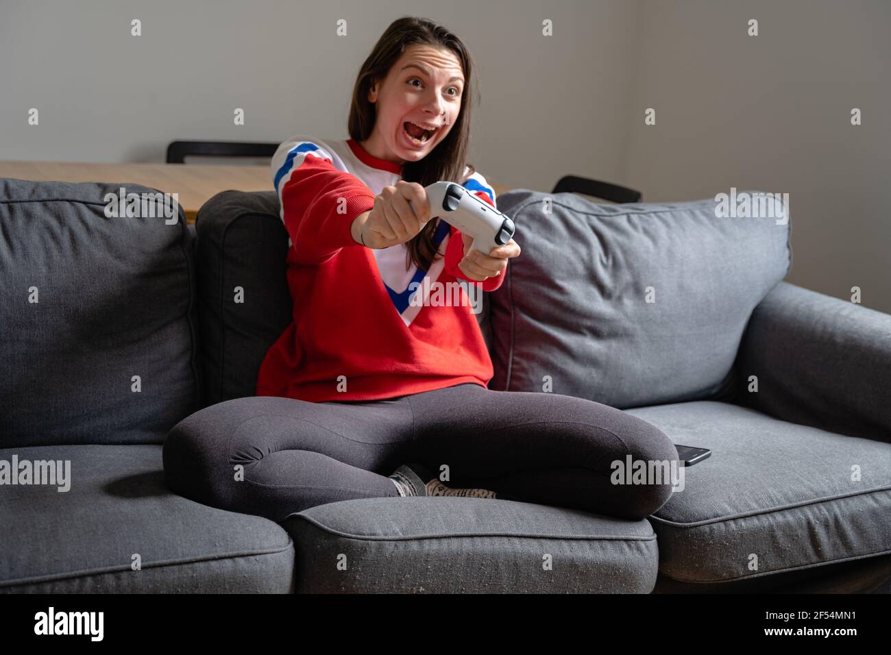 woman at home playing video games with wireless gamepad. Console gaming ...