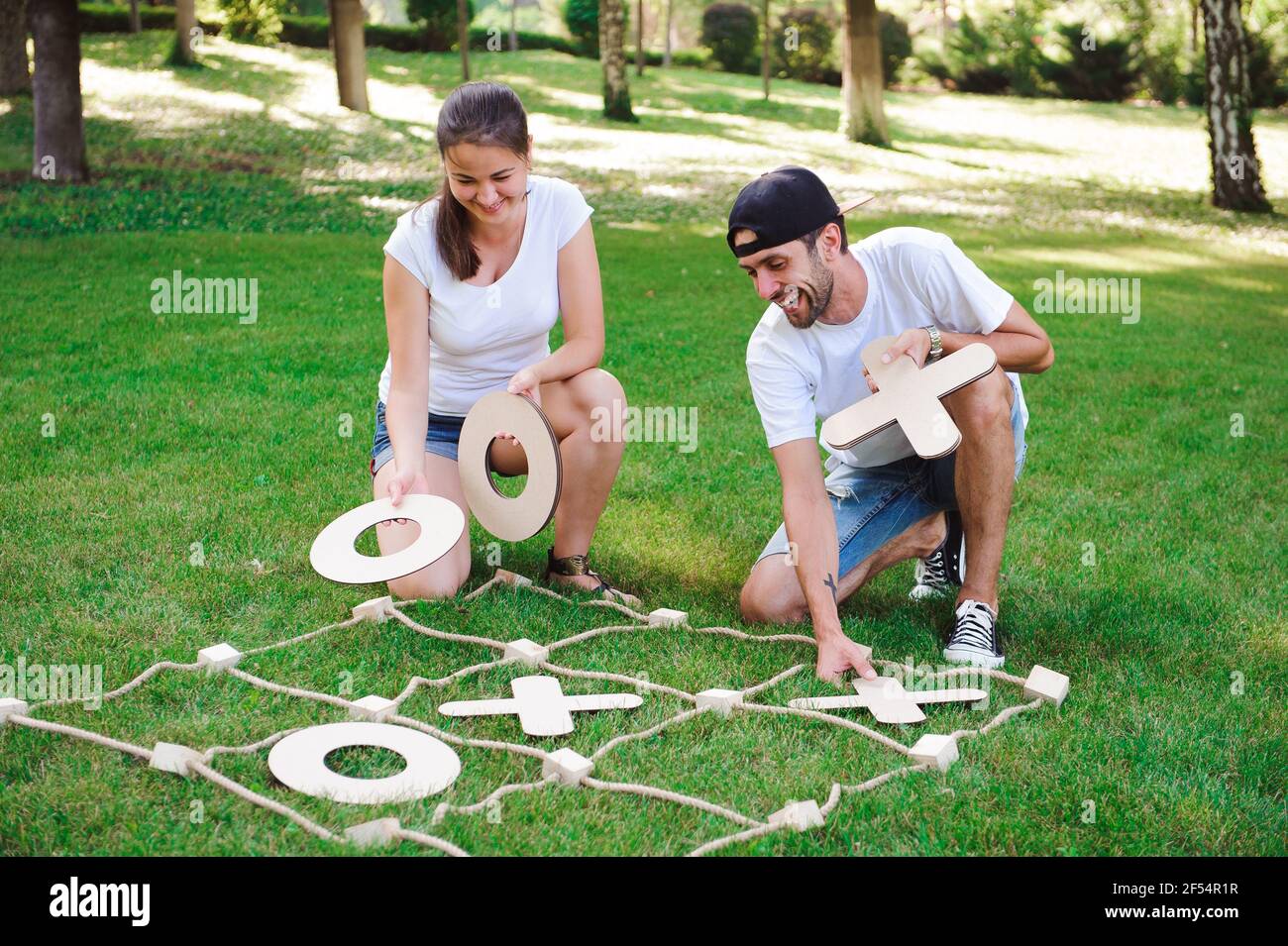 Big Tic Tac Toe game. Guy and girl playing outdoors Stock Photo - Alamy