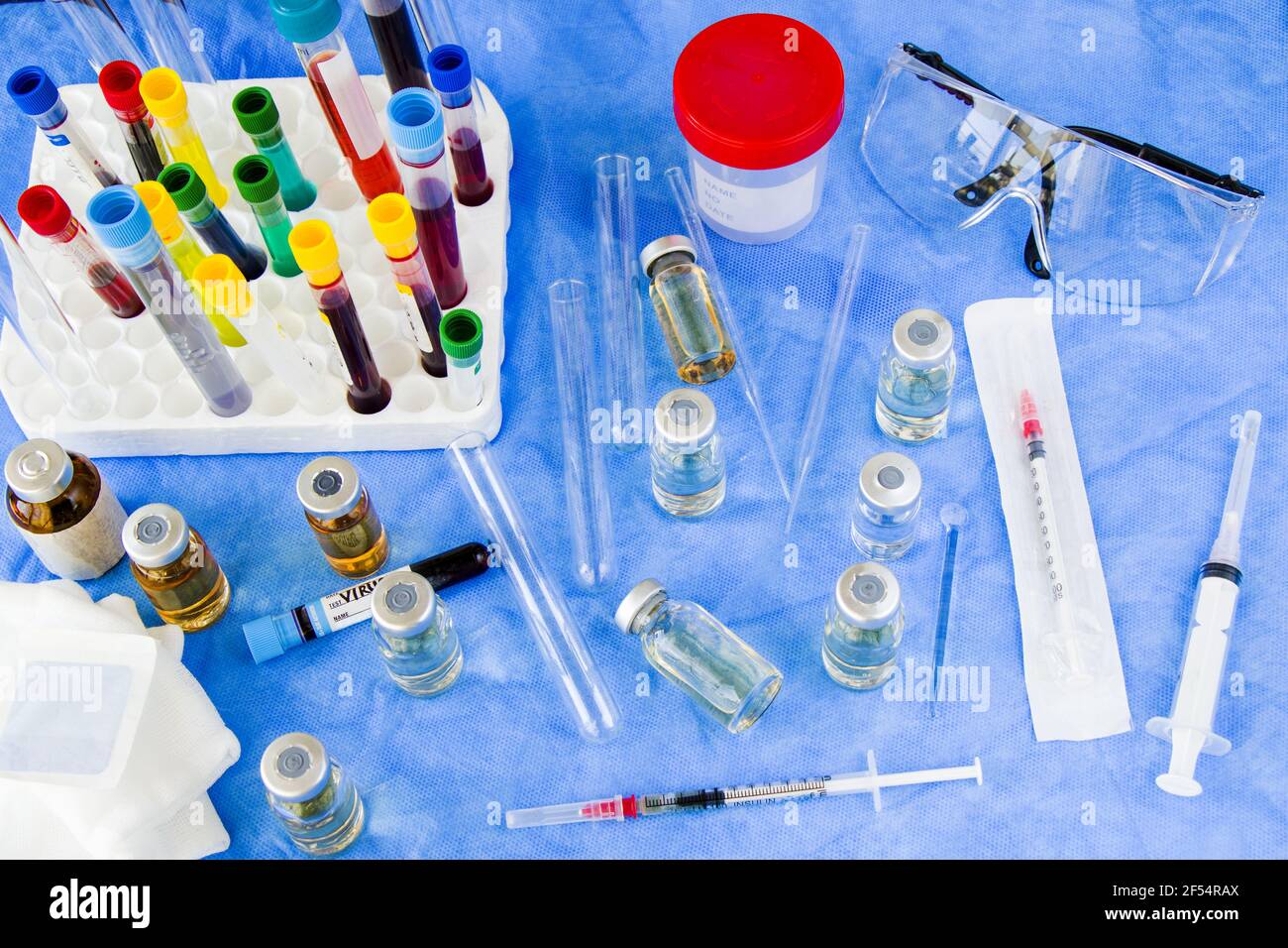 Needle, vaccine, and a drug bottle on the blue sterile table with ...