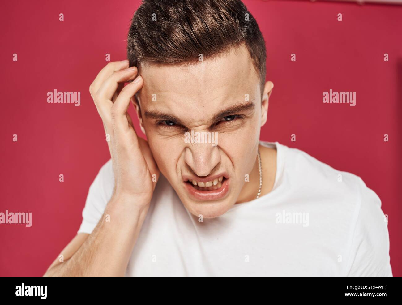 angry man displeased facial expression close up emotion red background ...