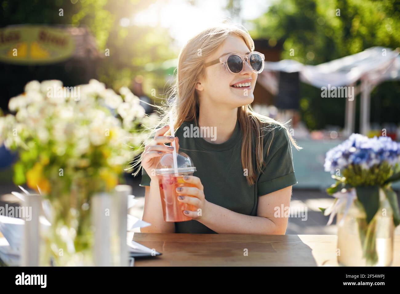 Portrait of young female food blogger drinking lemonade wearing glasses ...