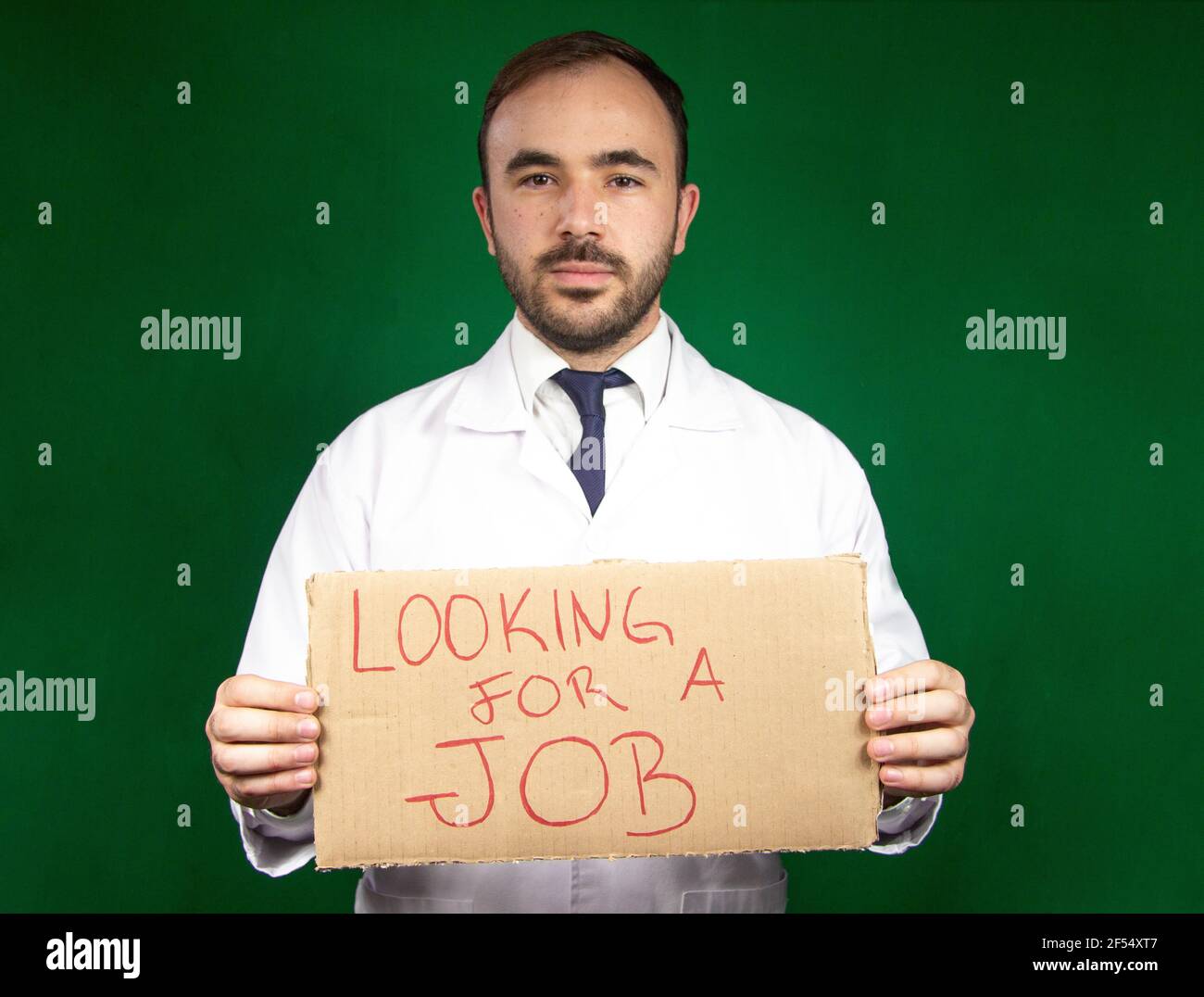 Young Mexican doctor with writing "Looking for a Job". Concept of ...