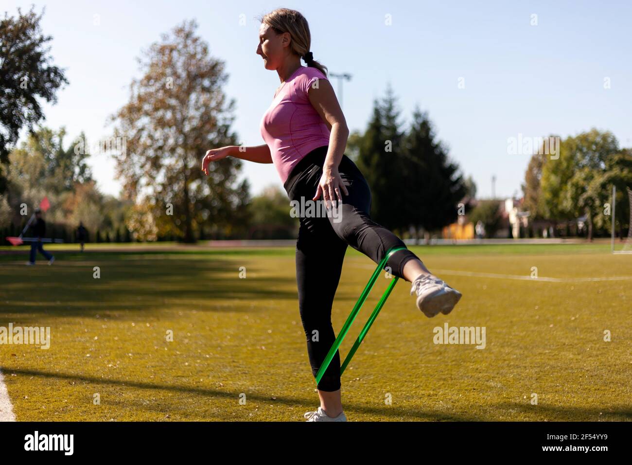 Girl exercising with a rubber band in the stadium Stock Photo - Alamy