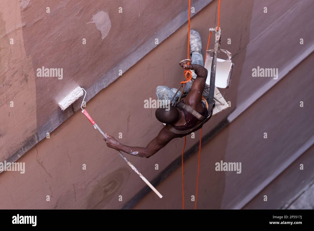 Painter Hanging on Rope and Painting a Building Wall Stock Photo - Alamy