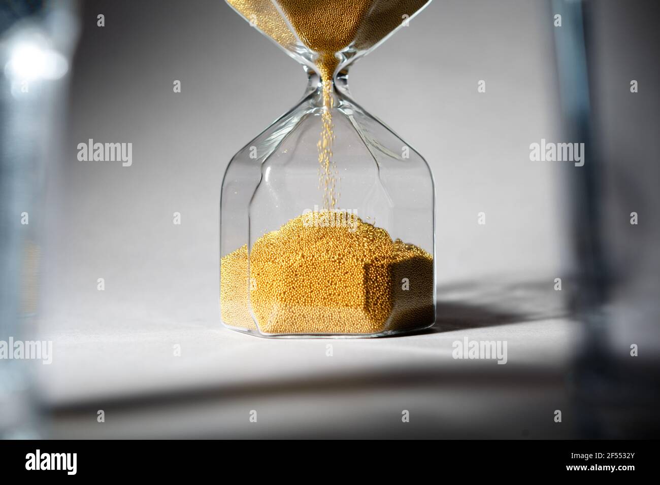 Hourglass with sand on gray background close up Stock Photo - Alamy