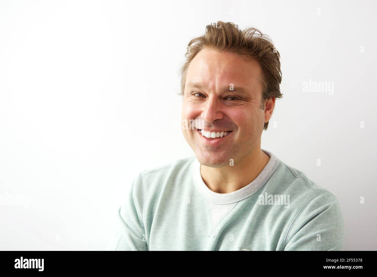 Close up portrait of good looking guy standing against white wall and ...