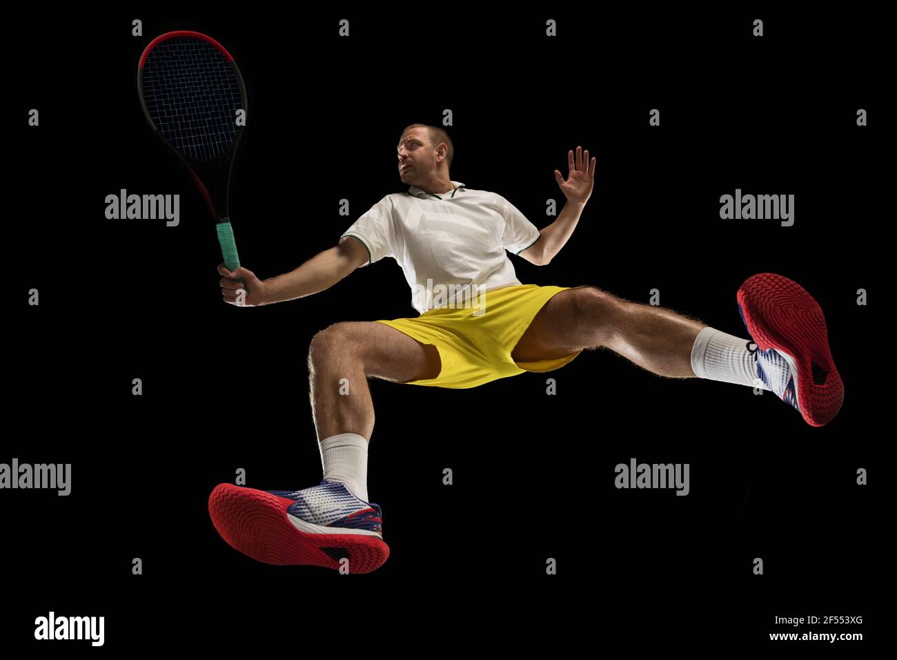 Young caucasian tennis player in action, motion isolated on black ...
