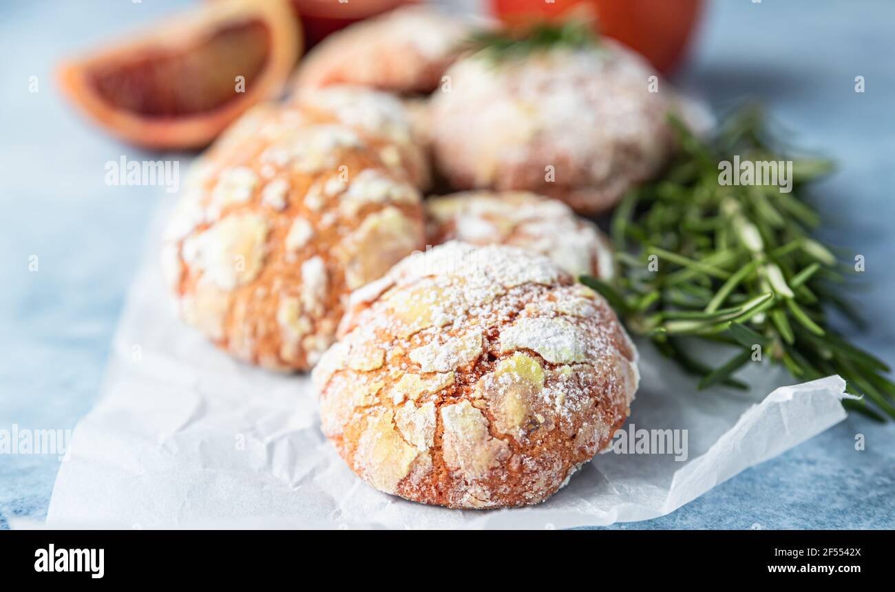 Homemade orange crinkle cookies with powdered sugar on baking paper ...