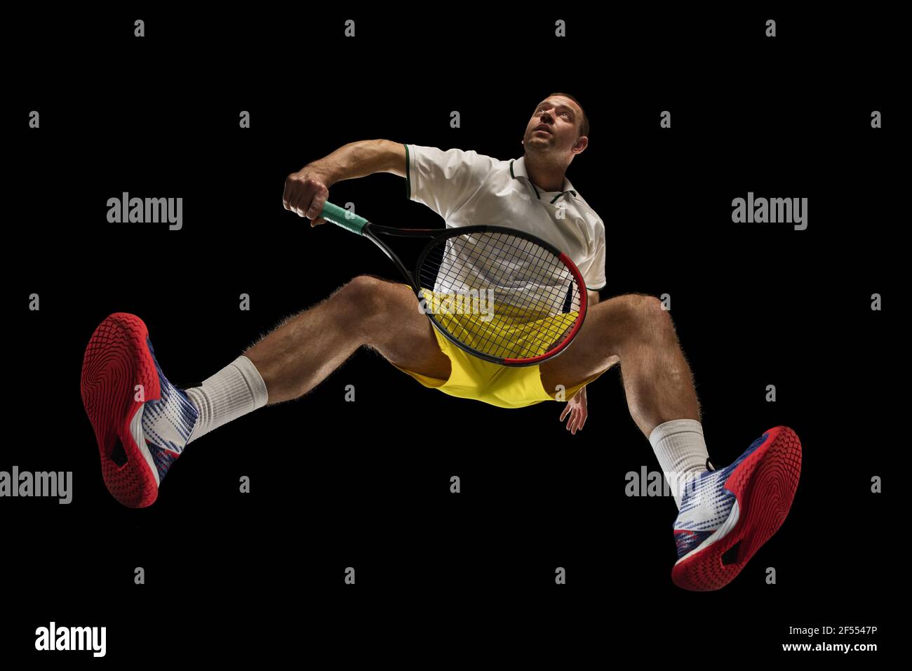 Young caucasian tennis player in action, motion isolated on black ...