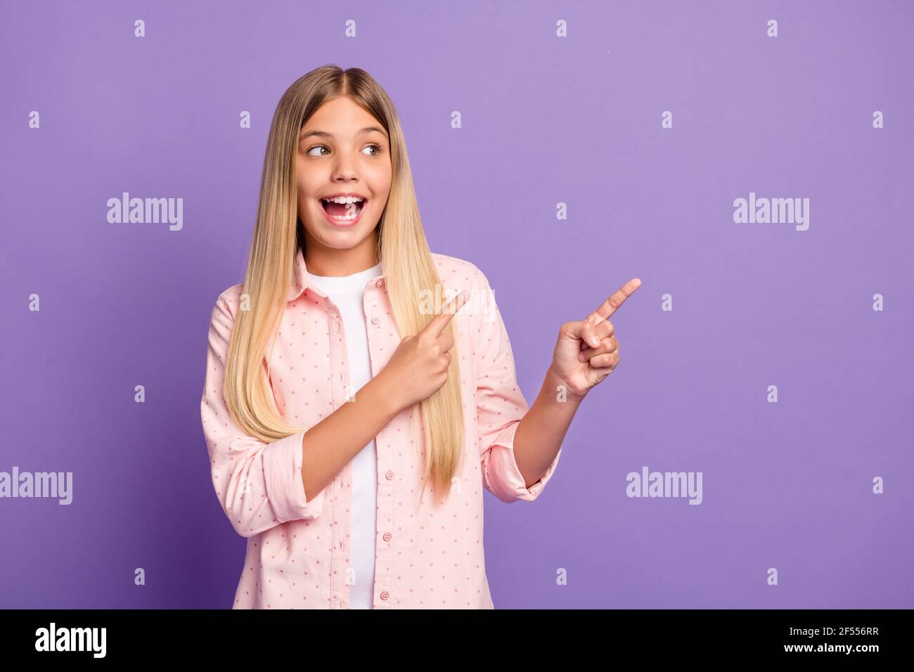 Photo of impressed long hairdo pretty girl point empty space wear pink ...