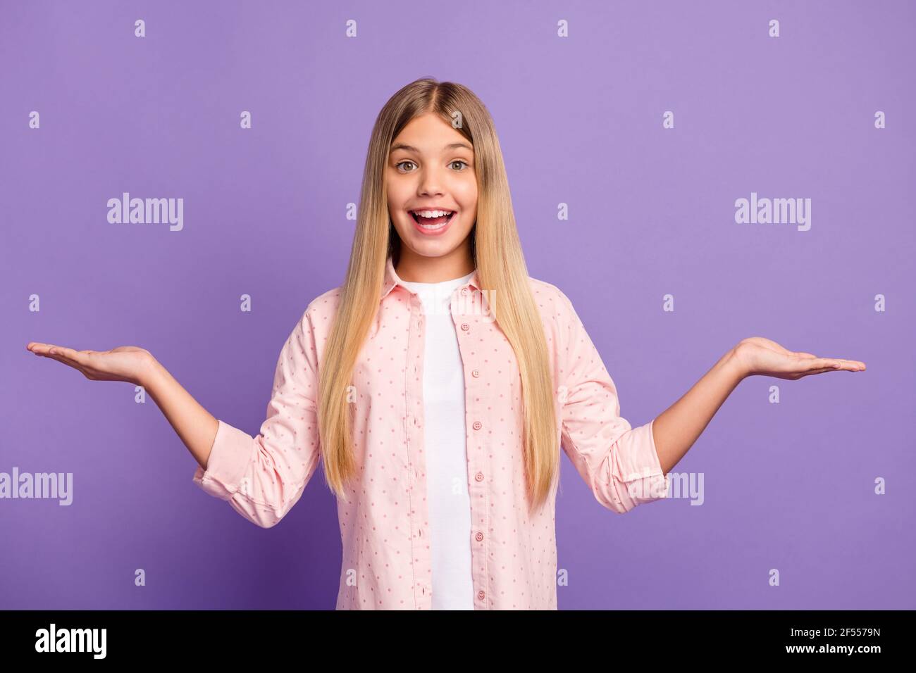 Photo of cheerful long hairdo pretty girl hold empty space wear pink ...