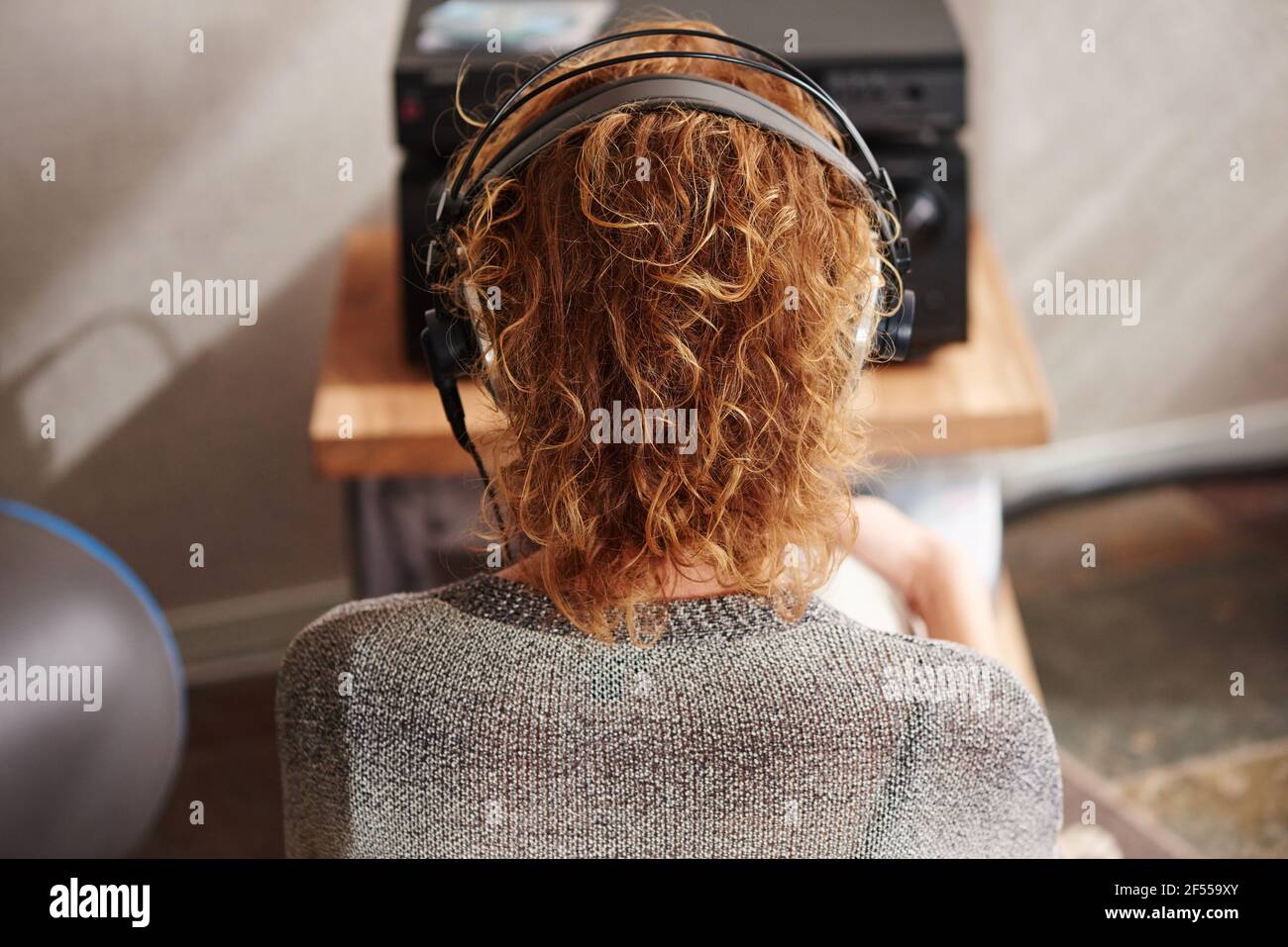 Portrait of woman from behind wearing headphones listening to music ...