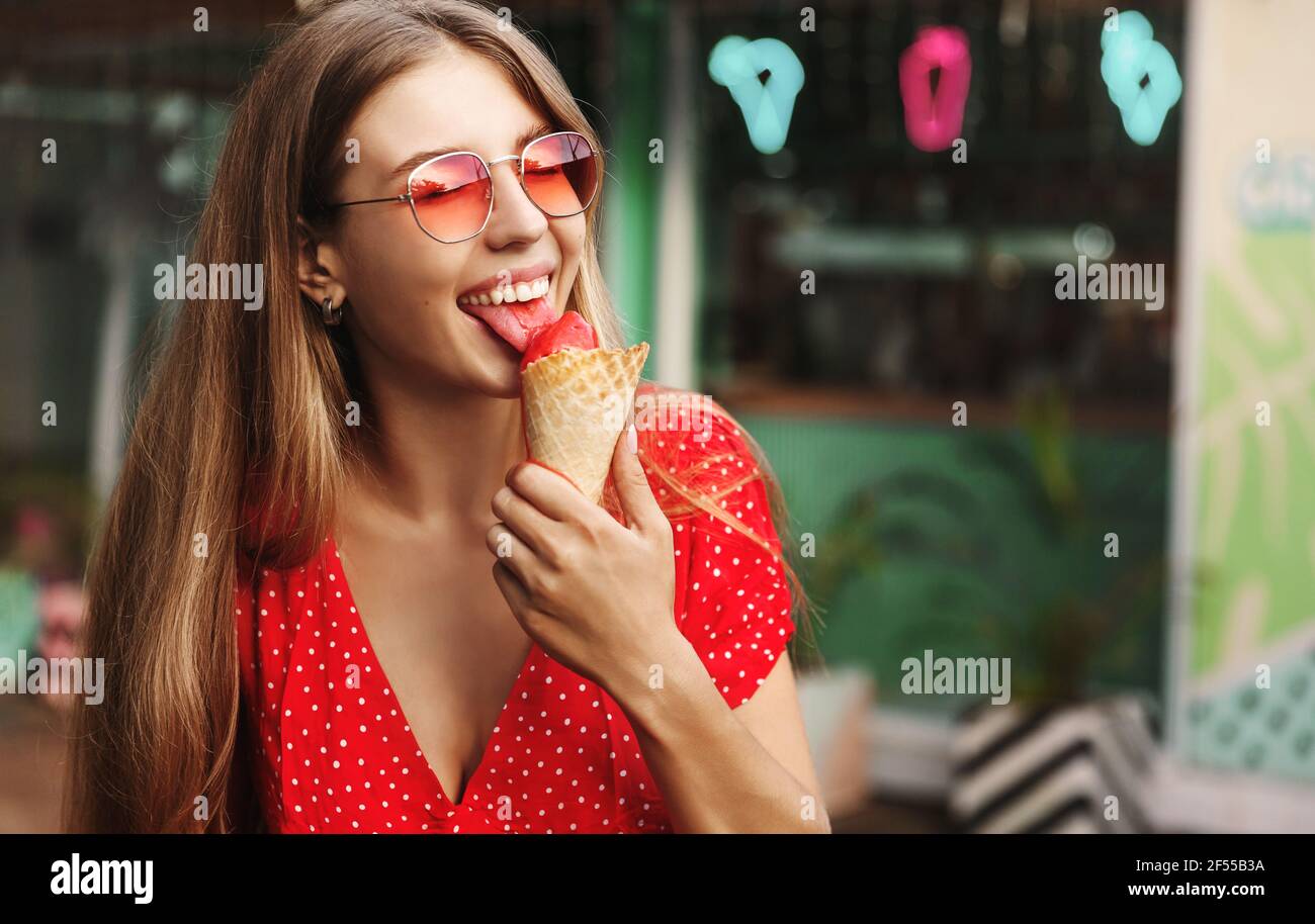 Happy young woman eating sweets on summer vacation. Female traveller ...