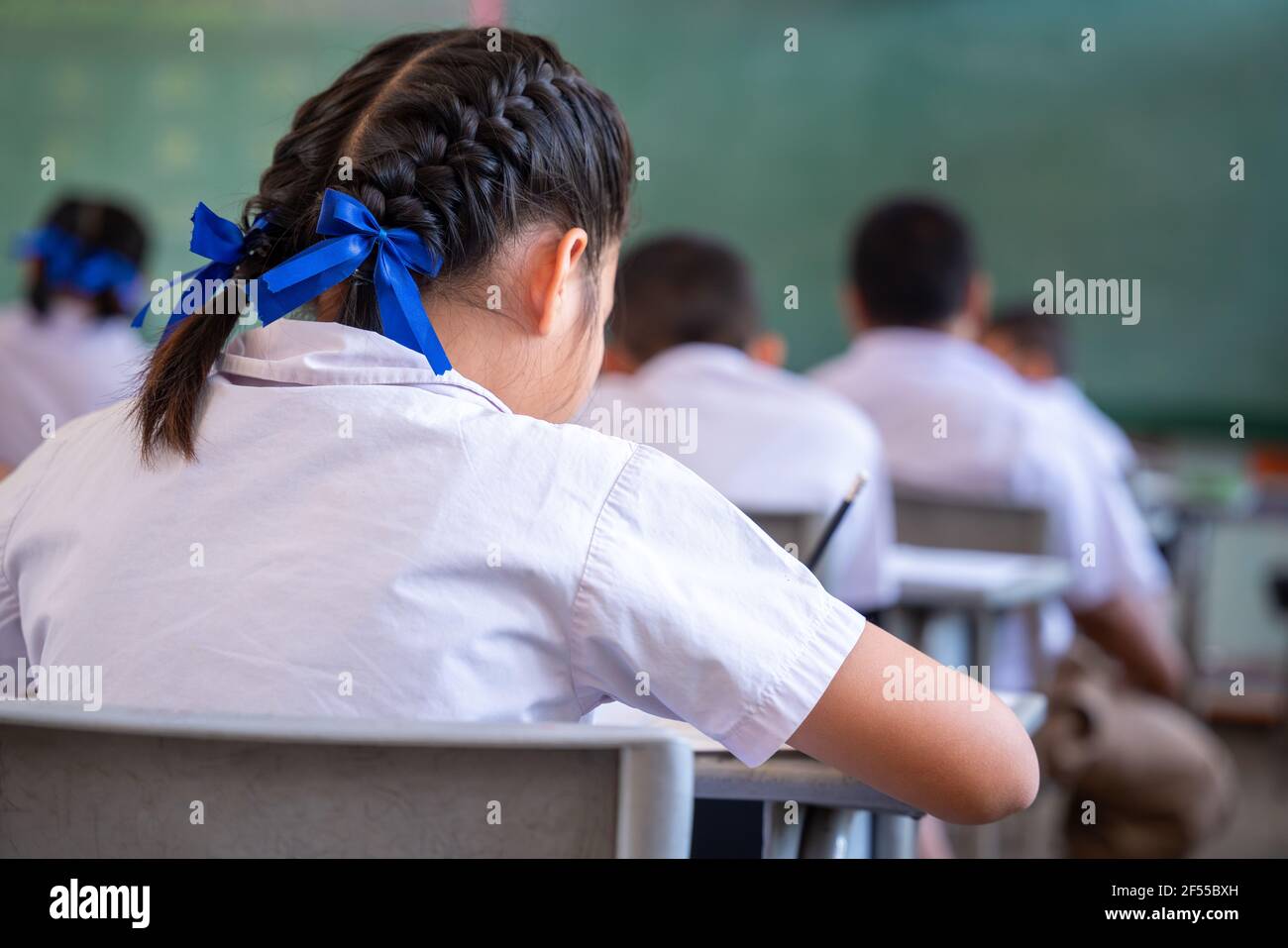 Close up of Writing test in exam with behind child asian students group ...