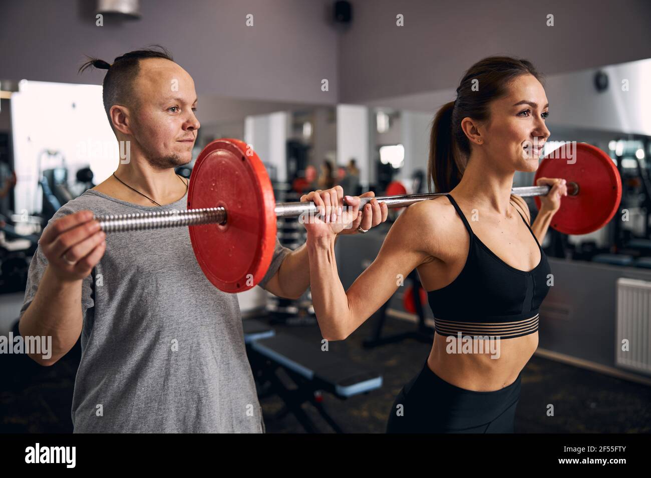 Young concentrated female person holding heavy barbell Stock Photo - Alamy