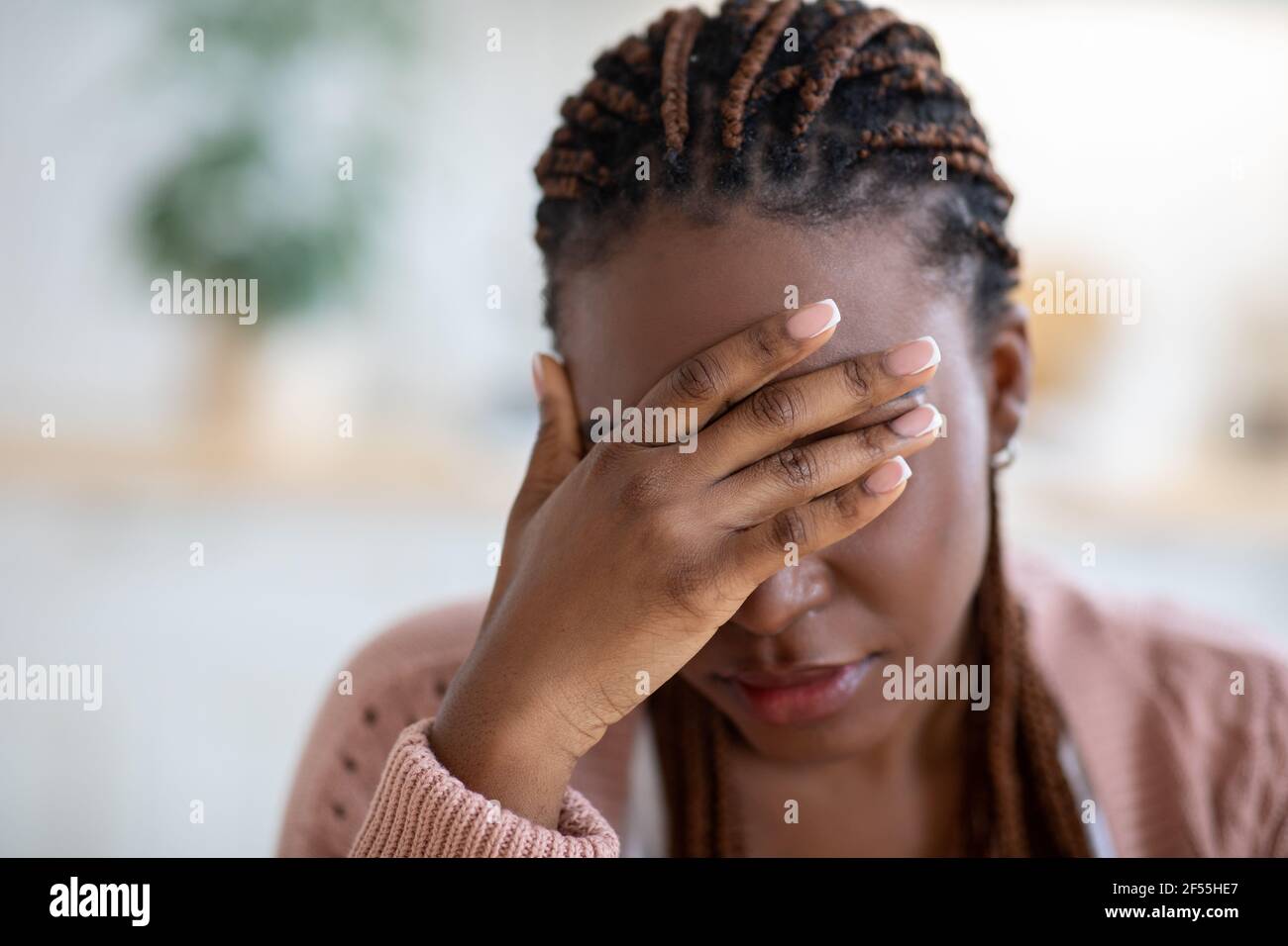 Closeup portrait of depressed young black woman touching head in ...