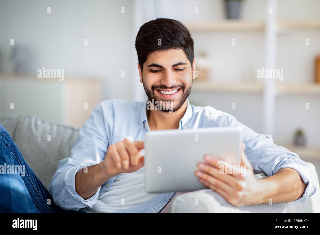 Happy arab man using digital tablet, shopping online, browsing internet ...