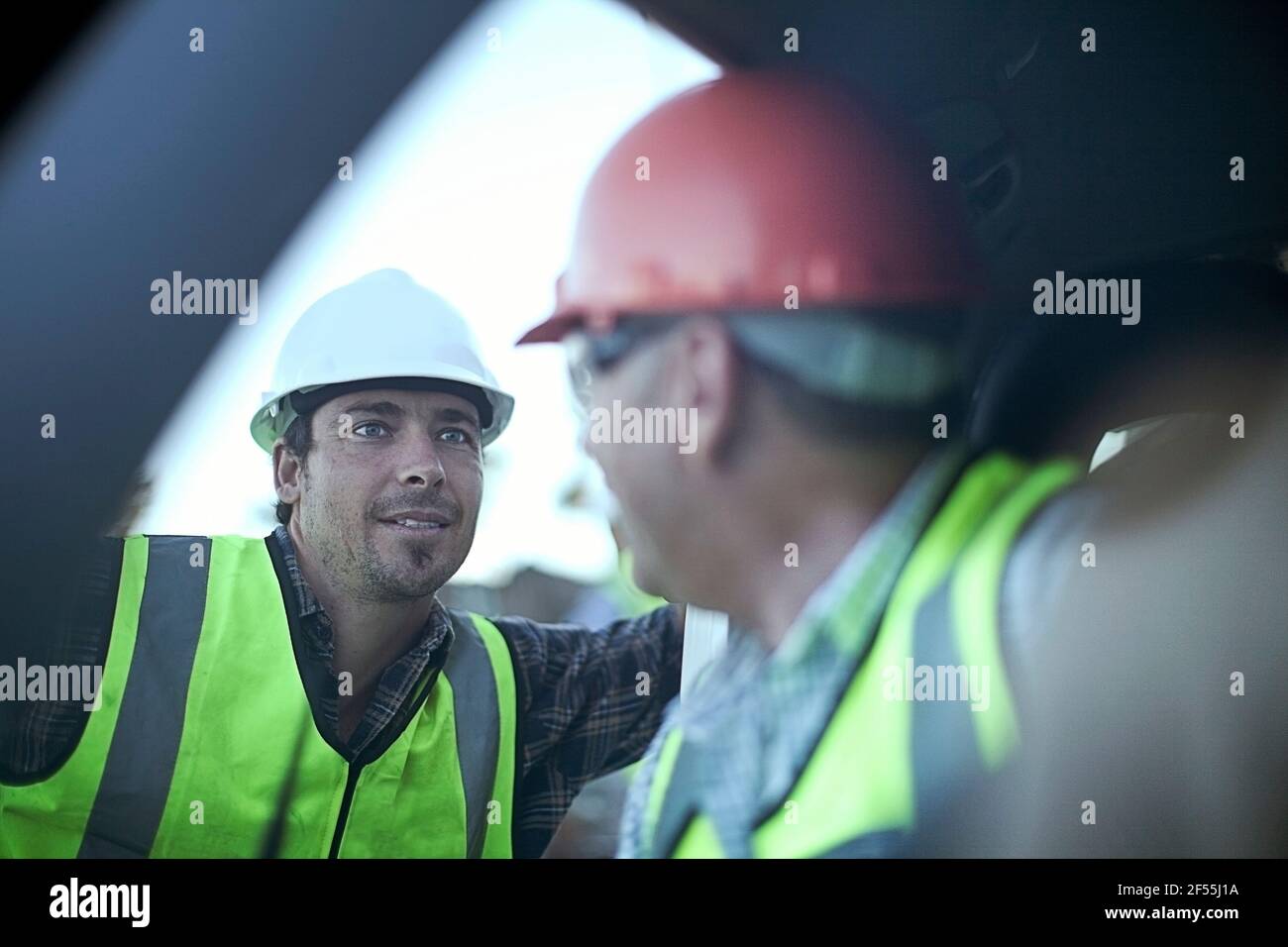 Two male construction workers chatting by car Stock Photo - Alamy