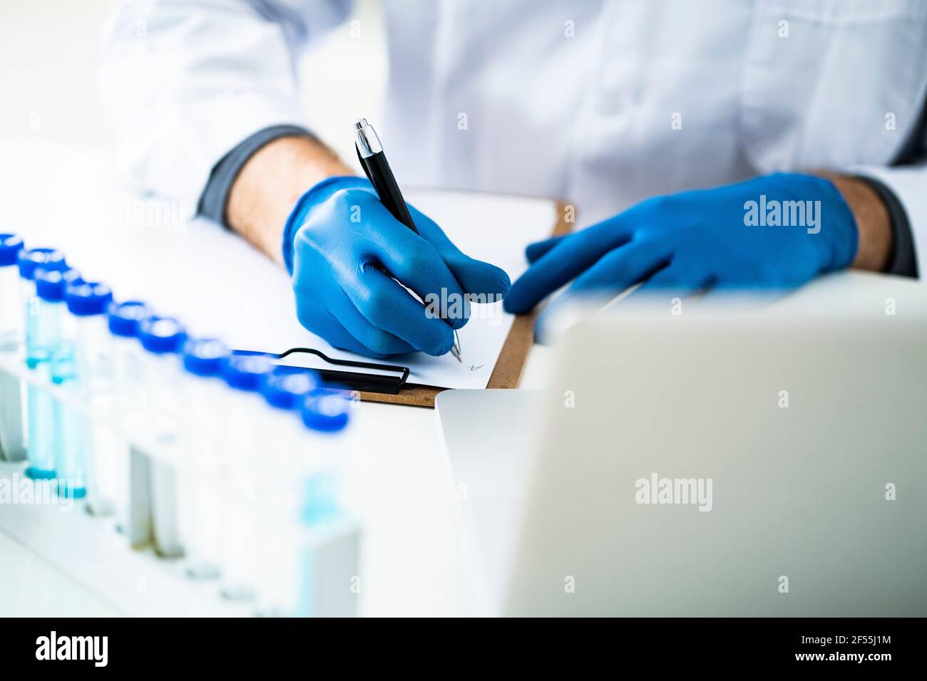 Male scientist writing notes on paper in laboratory Stock Photo - Alamy