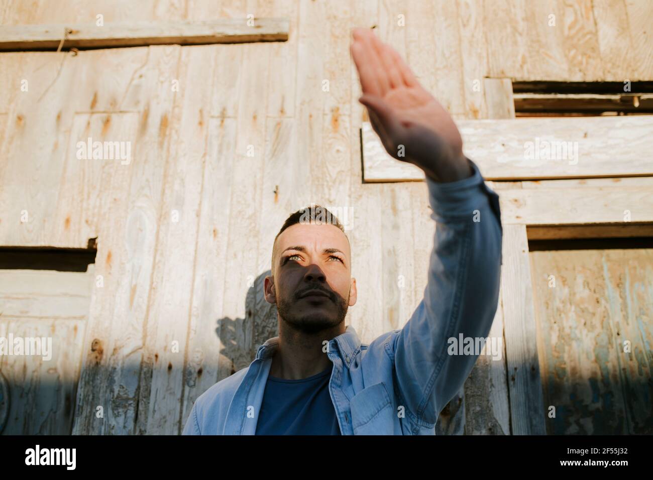 Man shielding his face through hand from sunlight while standing ...