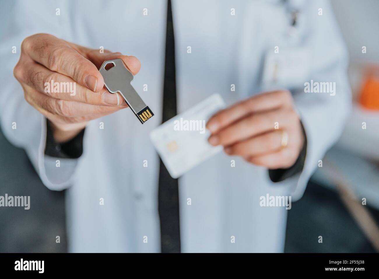 Male doctor holding USB stick while standing at clinic Stock Photo - Alamy
