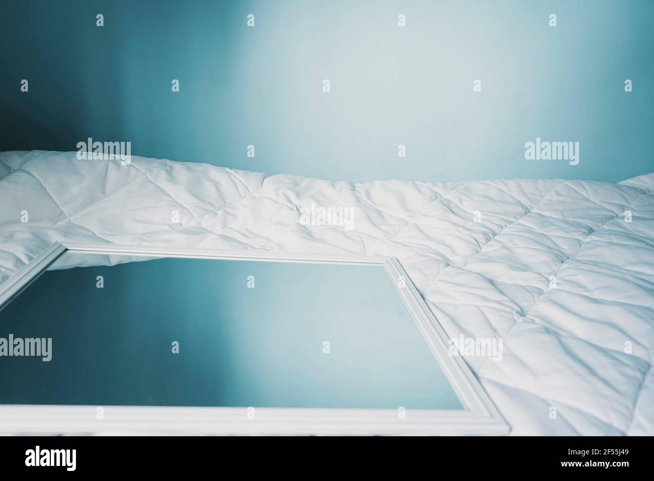 Mirror lying on white duvet Stock Photo - Alamy