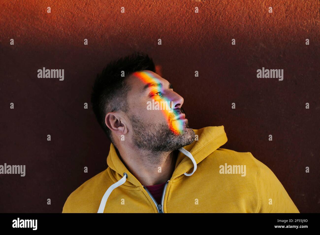 Spectrum falling on face of man lying on ground Stock Photo - Alamy