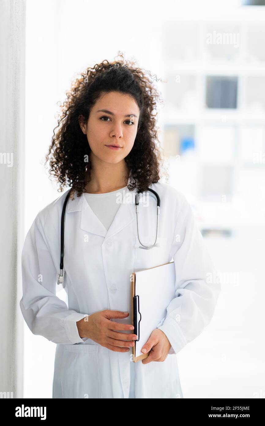 Confident female doctor with stethoscope and clipboard at hospital ...