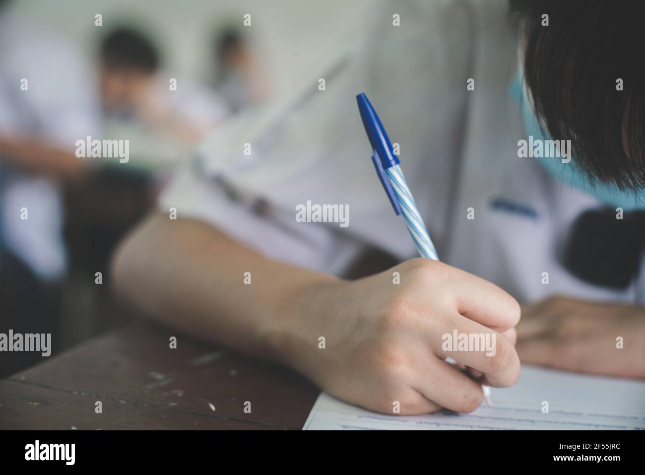 Students writing pencil in hand doing exams answer sheets exercises in ...