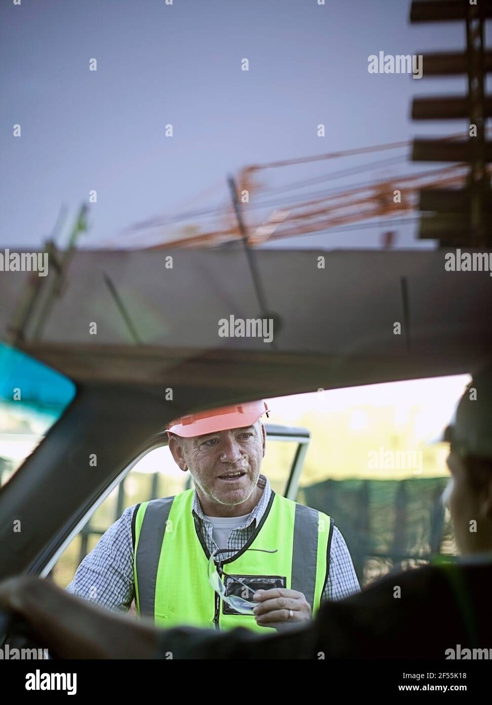 Two male construction workers chatting by car Stock Photo - Alamy
