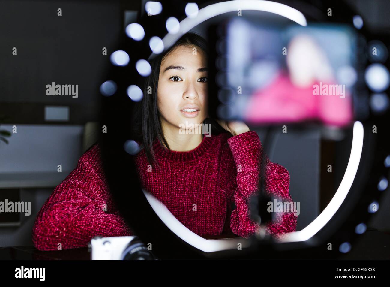 Young female influencer vlogging in darkroom Stock Photo - Alamy