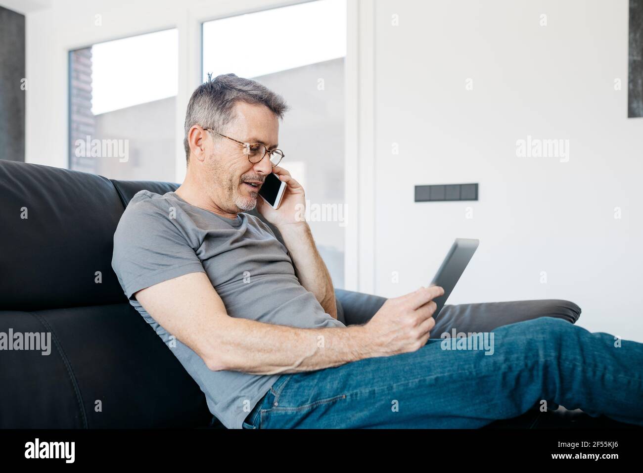 Mature man sitting couch living room using tablet hi-res stock ...