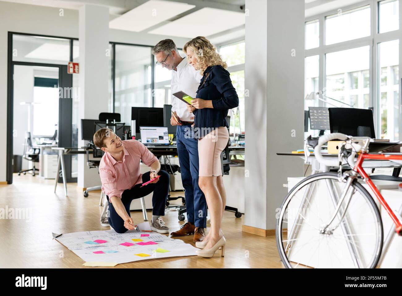 Male and female entrepreneurs assisting business project to colleague ...