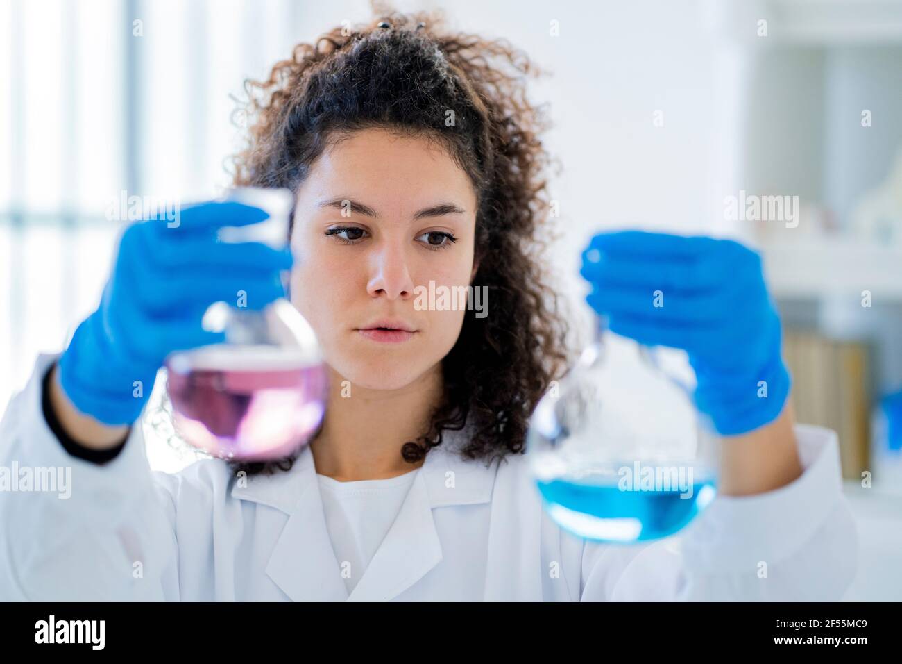 Female doctor testing chemical solution in beaker at laboratory Stock ...