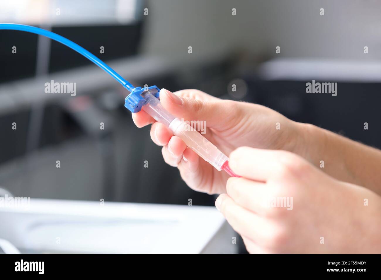 Researcher loading the ink cartridge of a 3D bioprinter to 3D print ...
