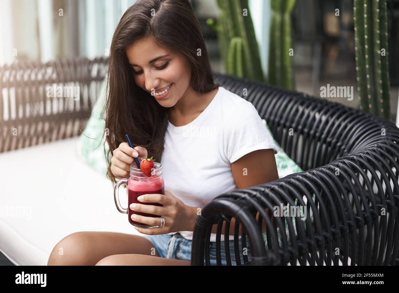 Lovely flirty young tanned girl enjoying tasty drink sit outdoor cafe ...