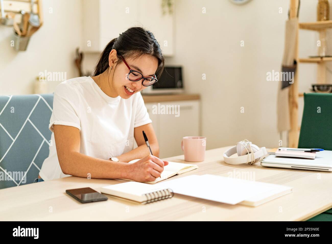 Smiling young student writing hi-res stock photography and images - Alamy