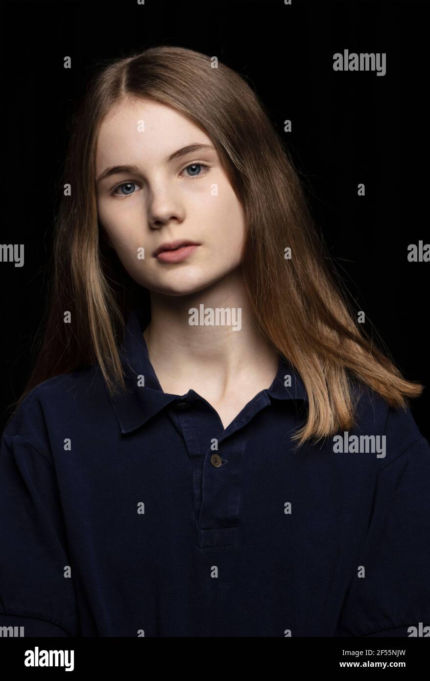 Serious girl against black background Stock Photo - Alamy