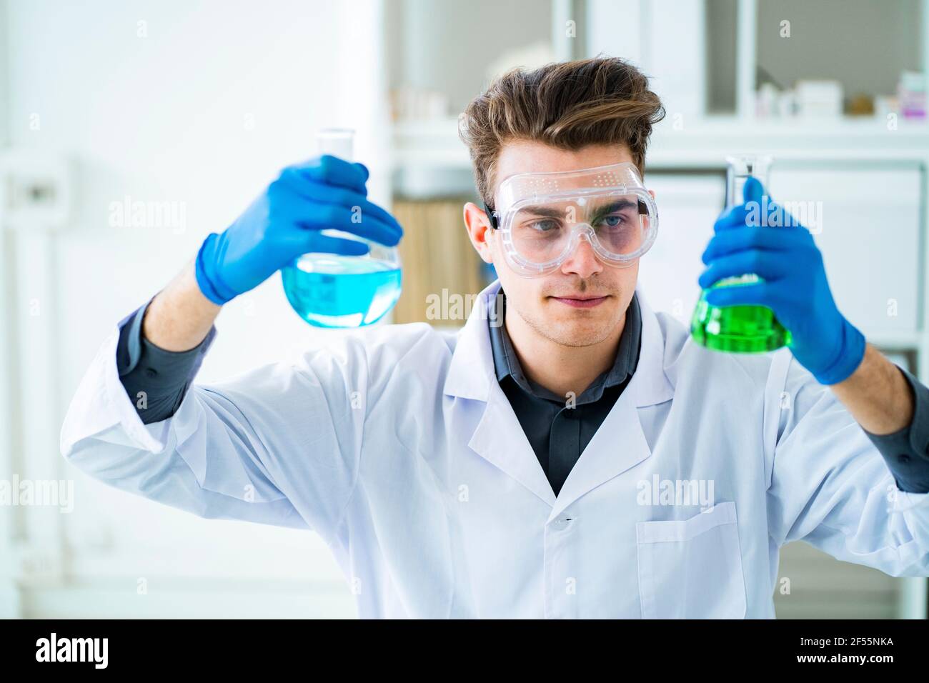 Male scientist holding chemical flasks in laboratory Stock Photo - Alamy