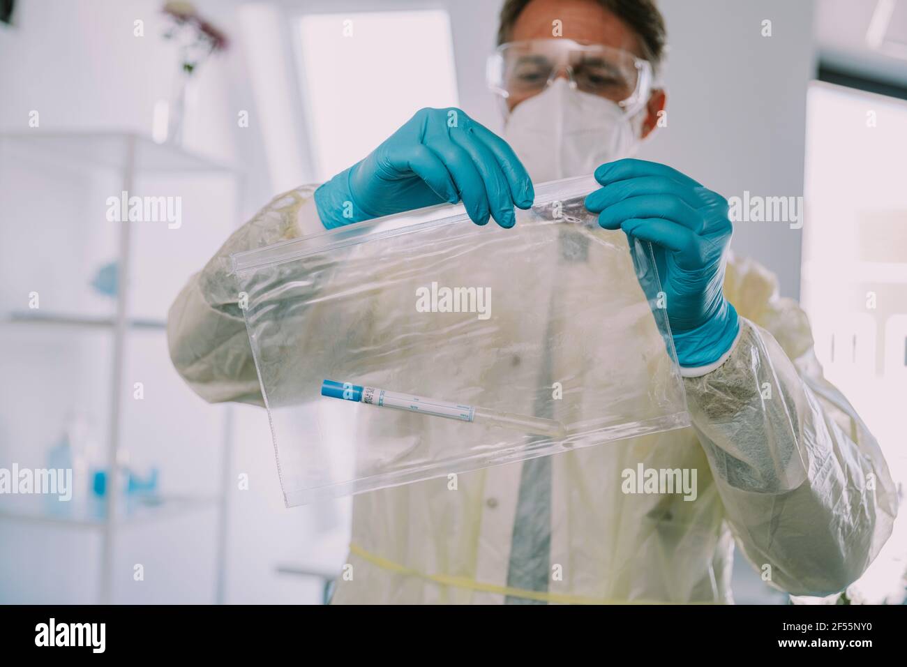 Expertise packing nasal swab sample test tube in plastic bag while ...