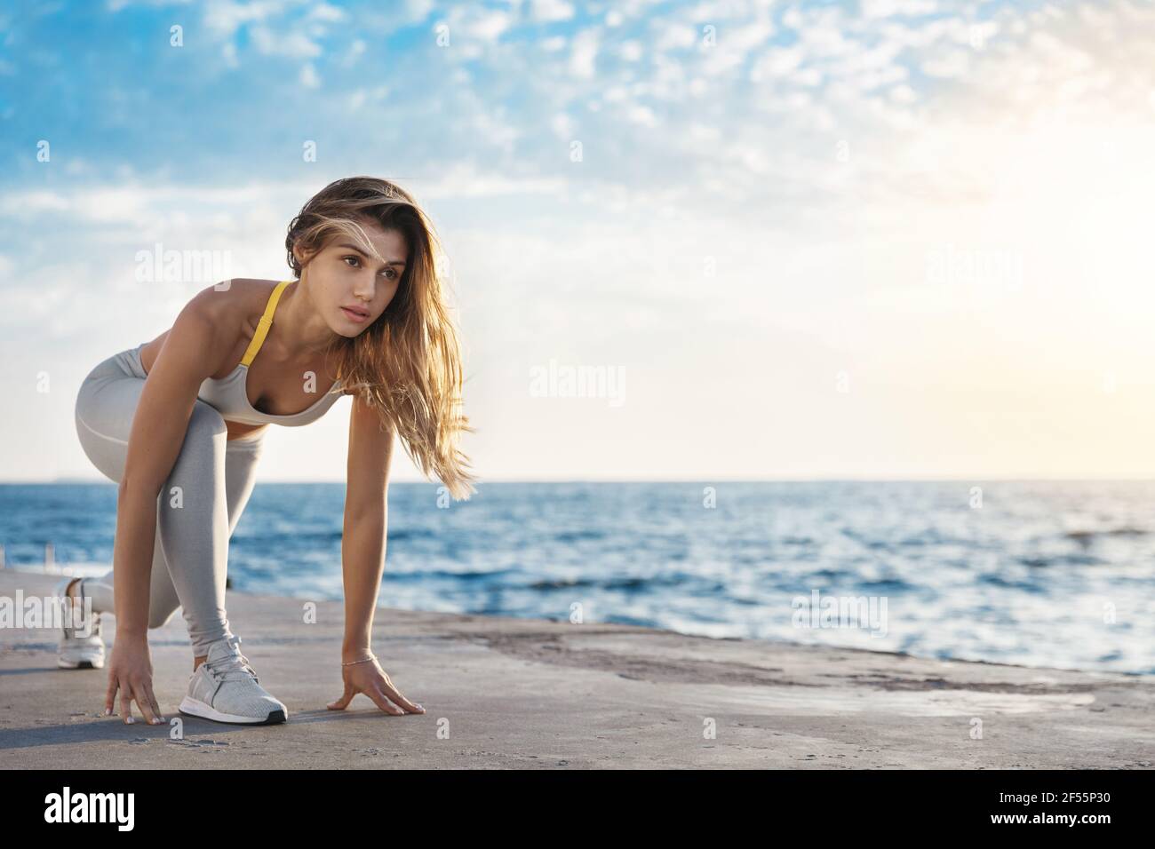 Motivated attractive fit sporty caucasian sportswoman low start pose ...