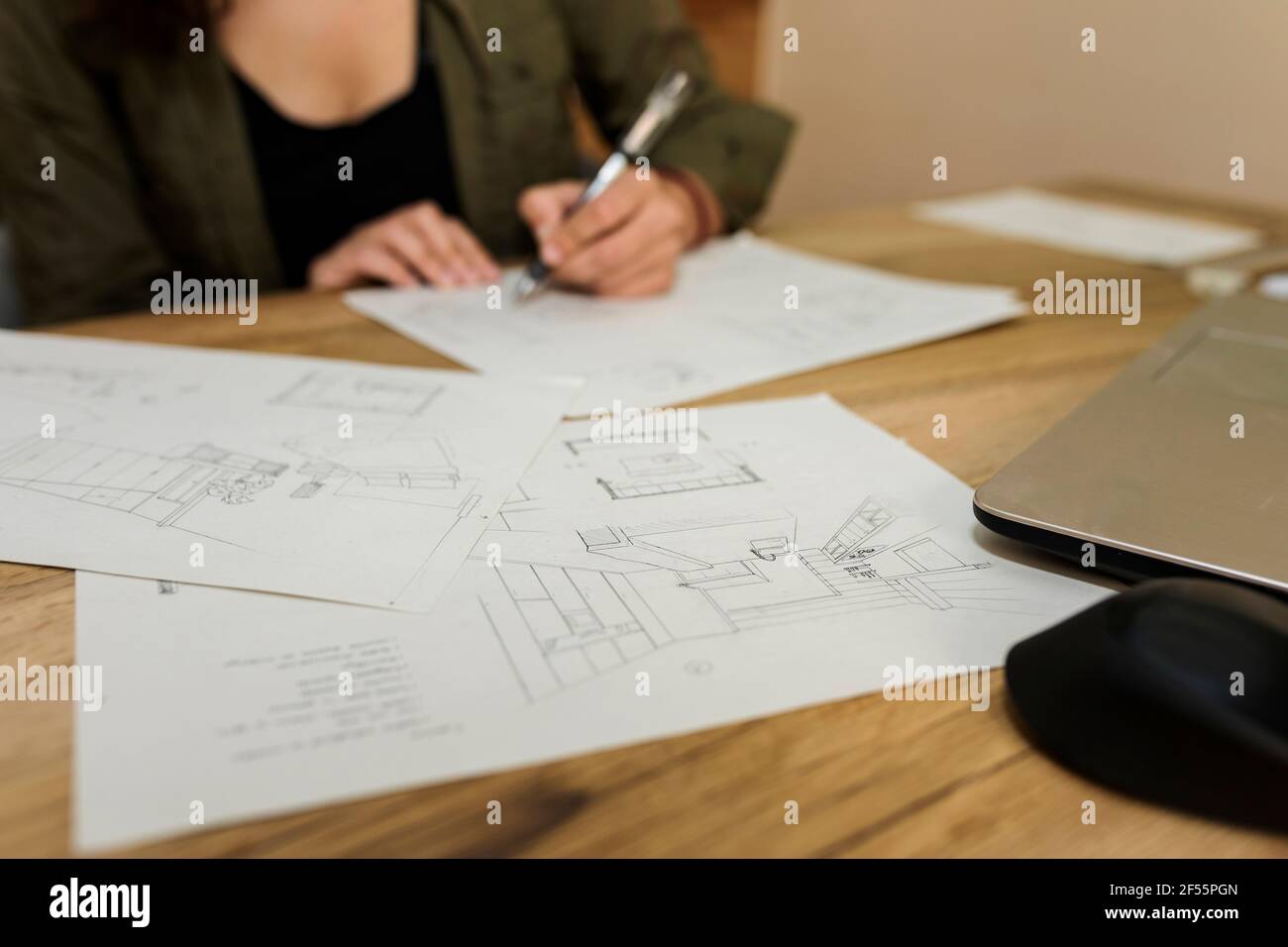 Mid adult female design professional making drawing on paper while ...