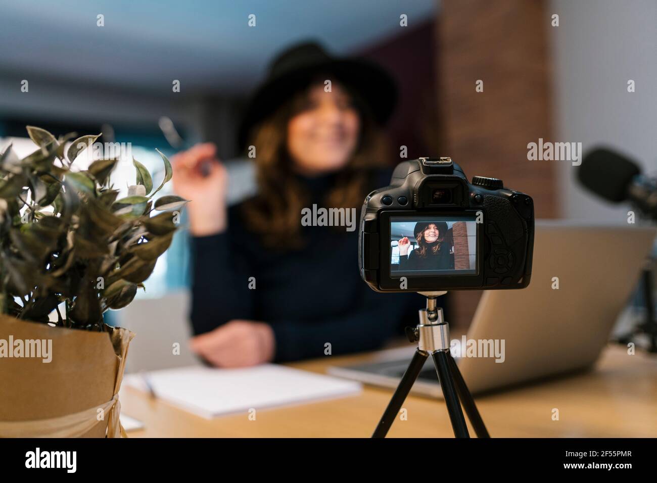 Mature woman filming through camera on tripod at home Stock Photo - Alamy