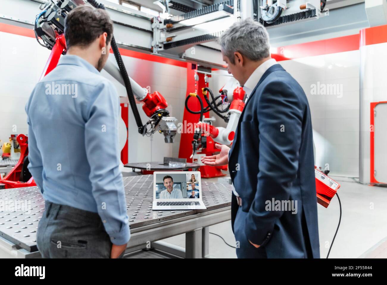 Mature male entrepreneur discussing during video call through laptop ...