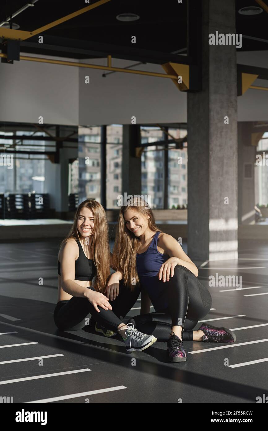 Vertical shot two sisters, gorgeous sisters in activewear, leggings ...