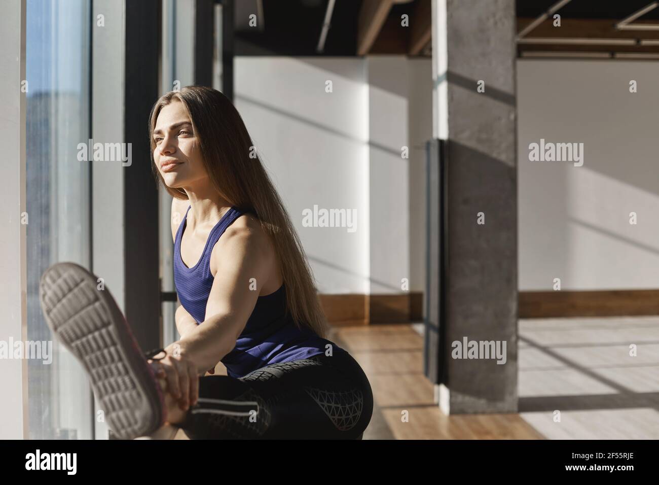 Attractive young sporty and healthy woman stretching on dance handrail ...