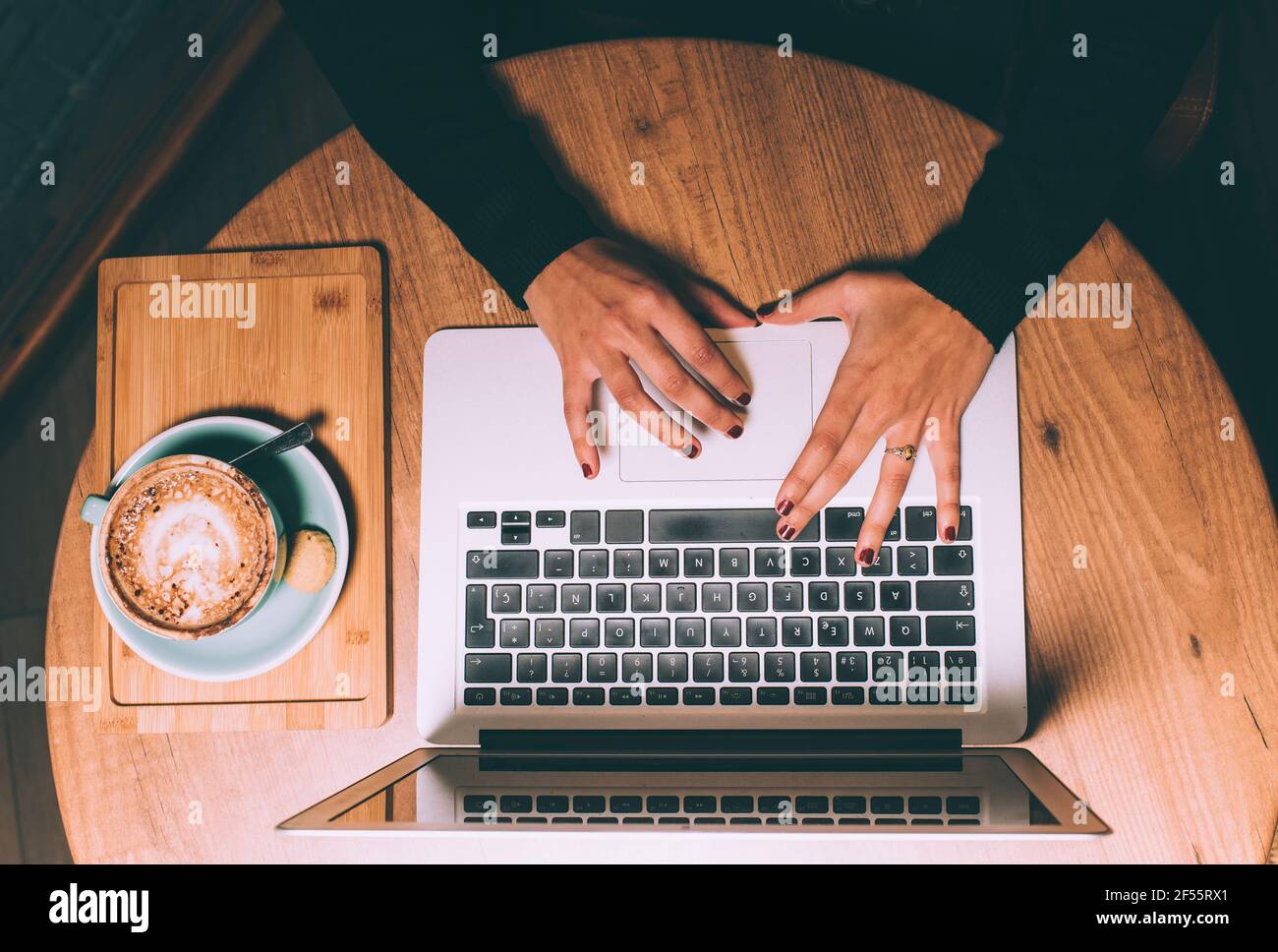 Female professional typing while using laptop in coffee shop Stock ...