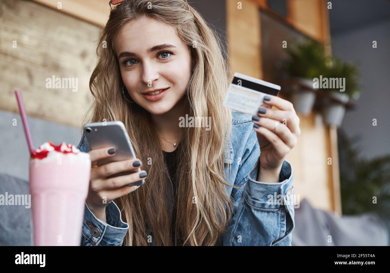 Eating out and candid people concept. Young blond woman paying for ...