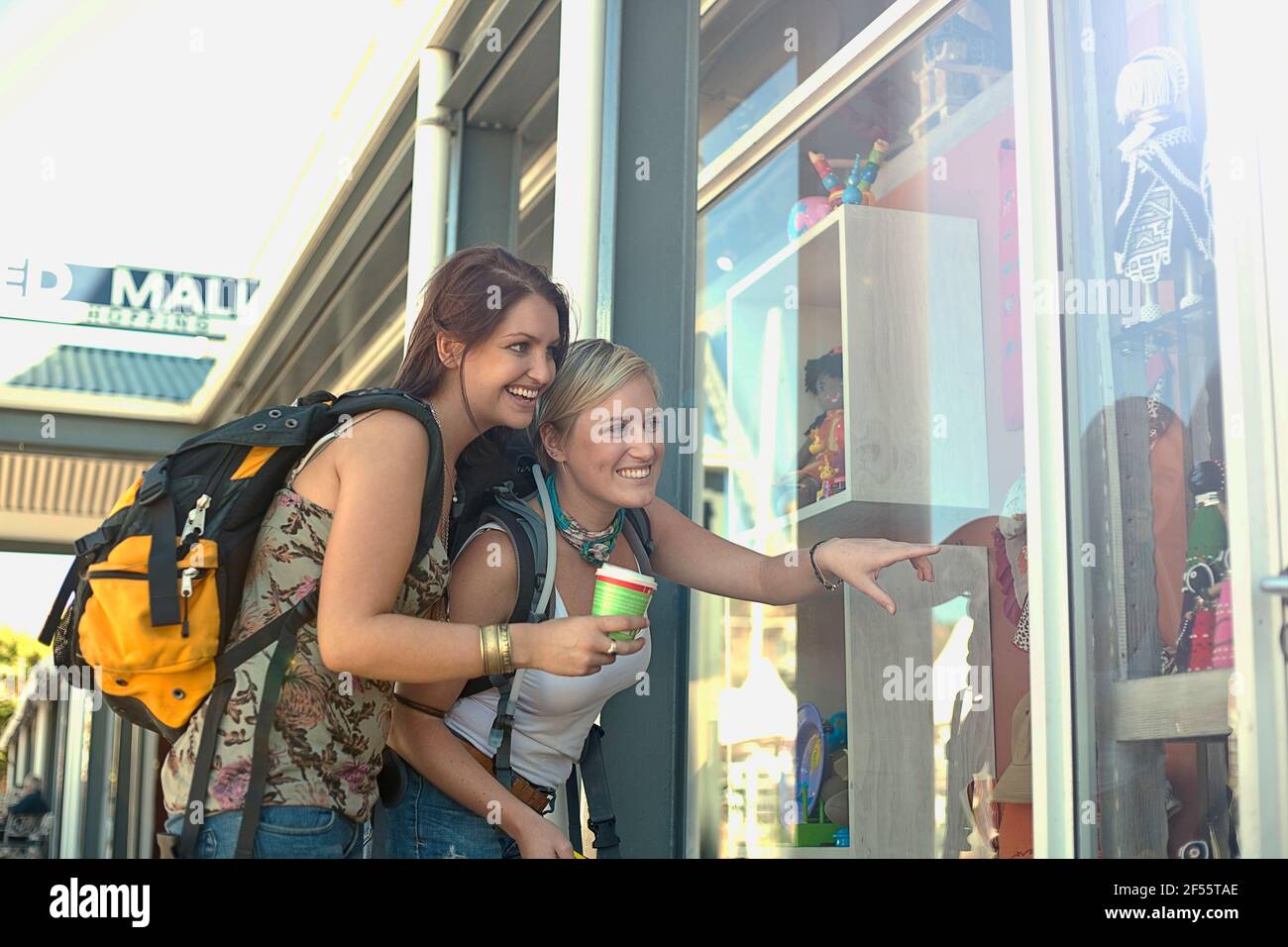 Female friends looking at window display of store Stock Photo - Alamy