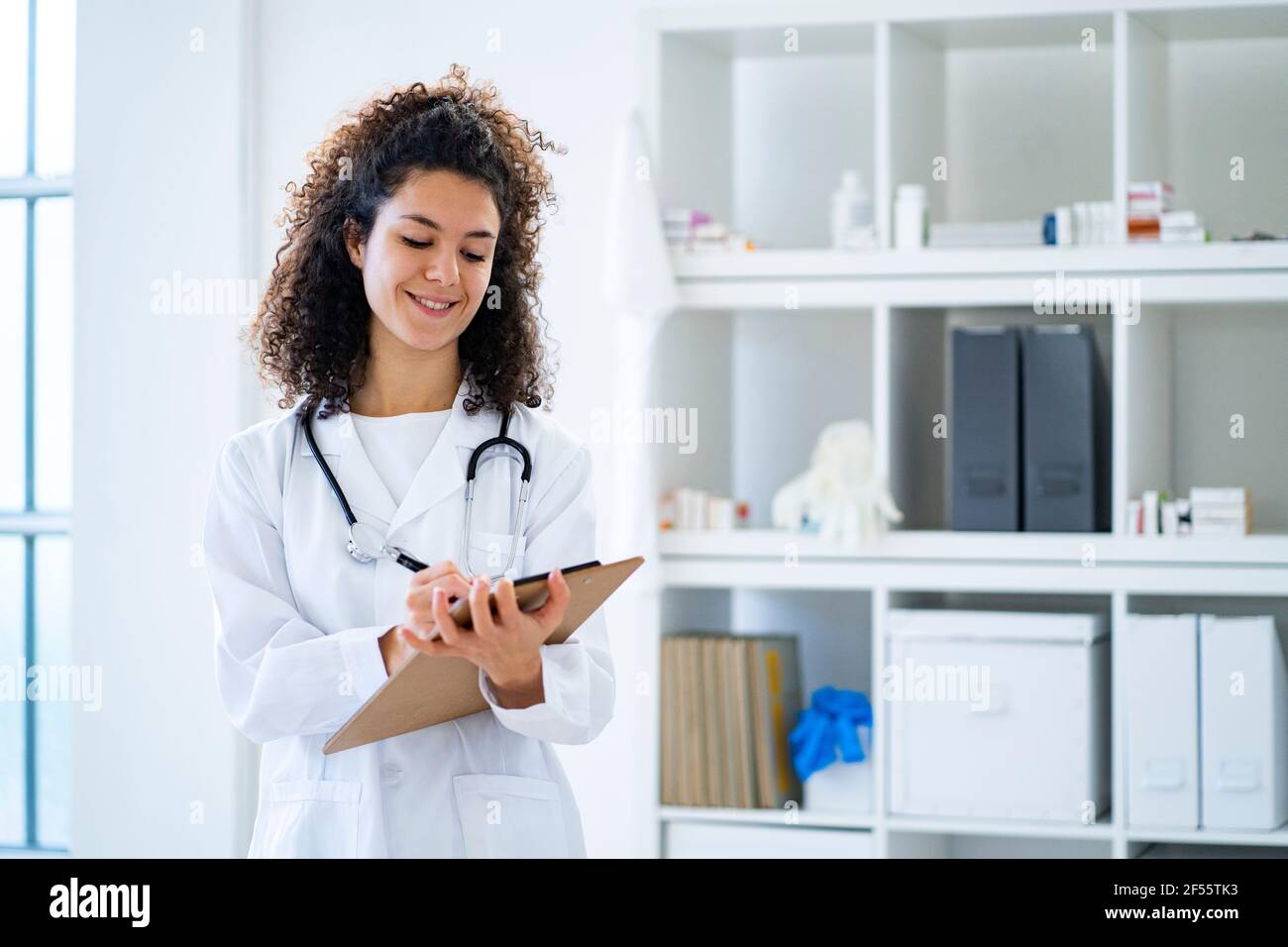 Female scientist holding clipboard checking hi-res stock photography ...